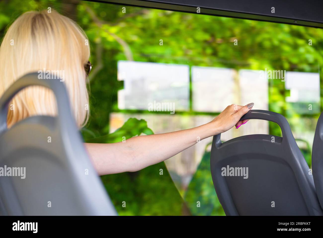 woman on the bus holding the handle on the chair. man in transport ...