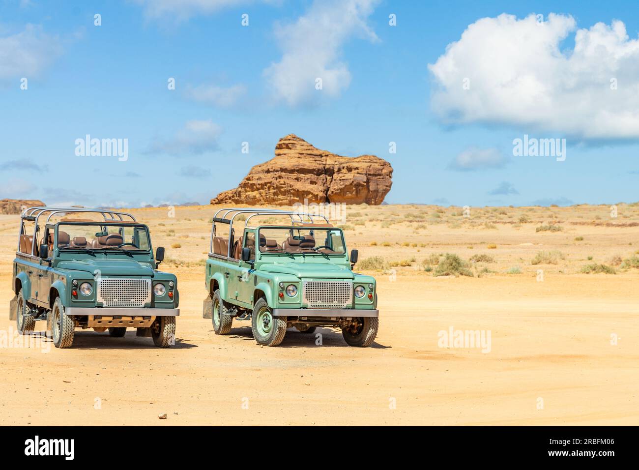 Off-road cars and desert cliffs formations landscape at Hegra, Al Ula ...