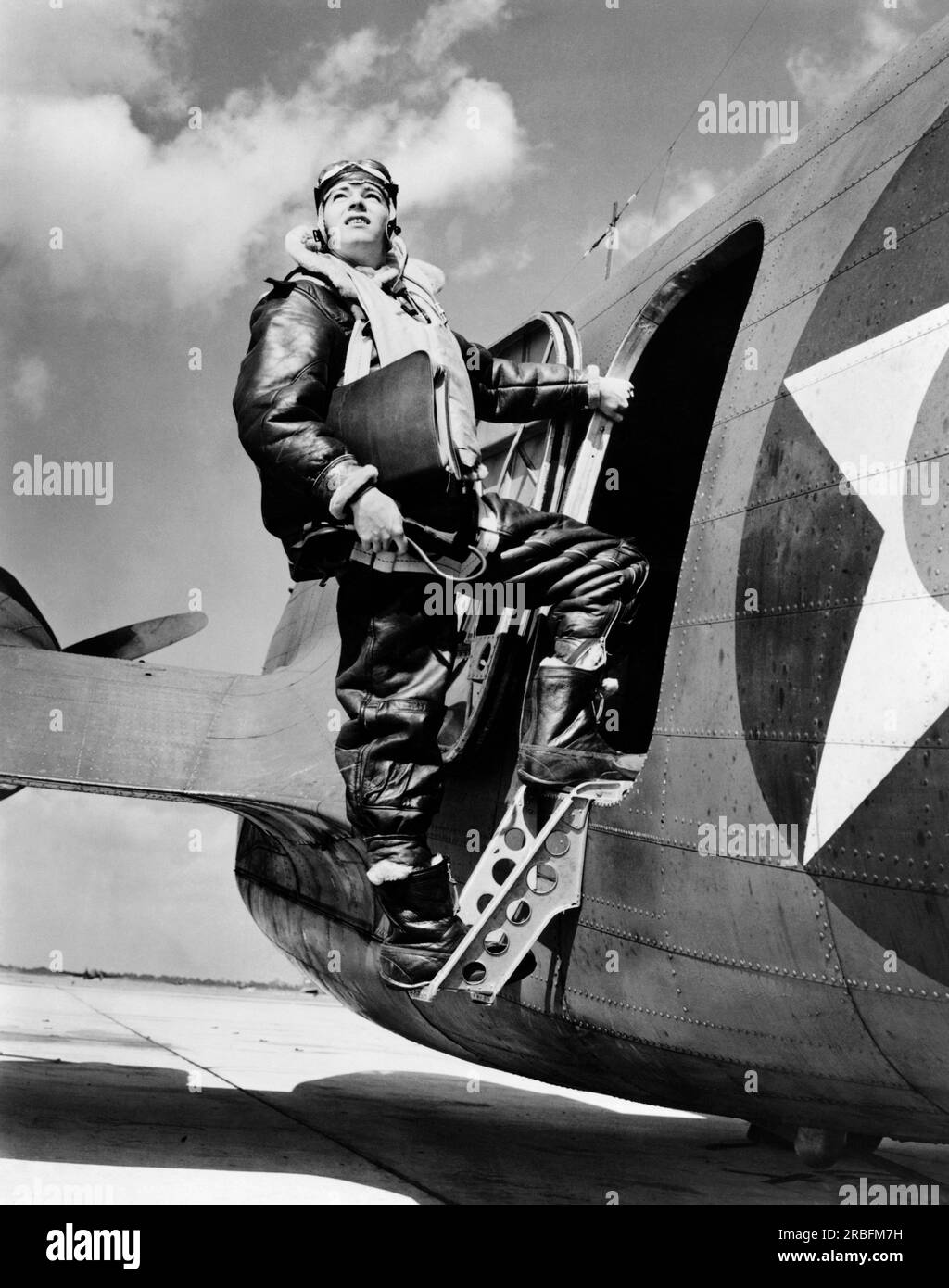 United States: c. 1945 An Army Air Force navigator boarding his plane ...