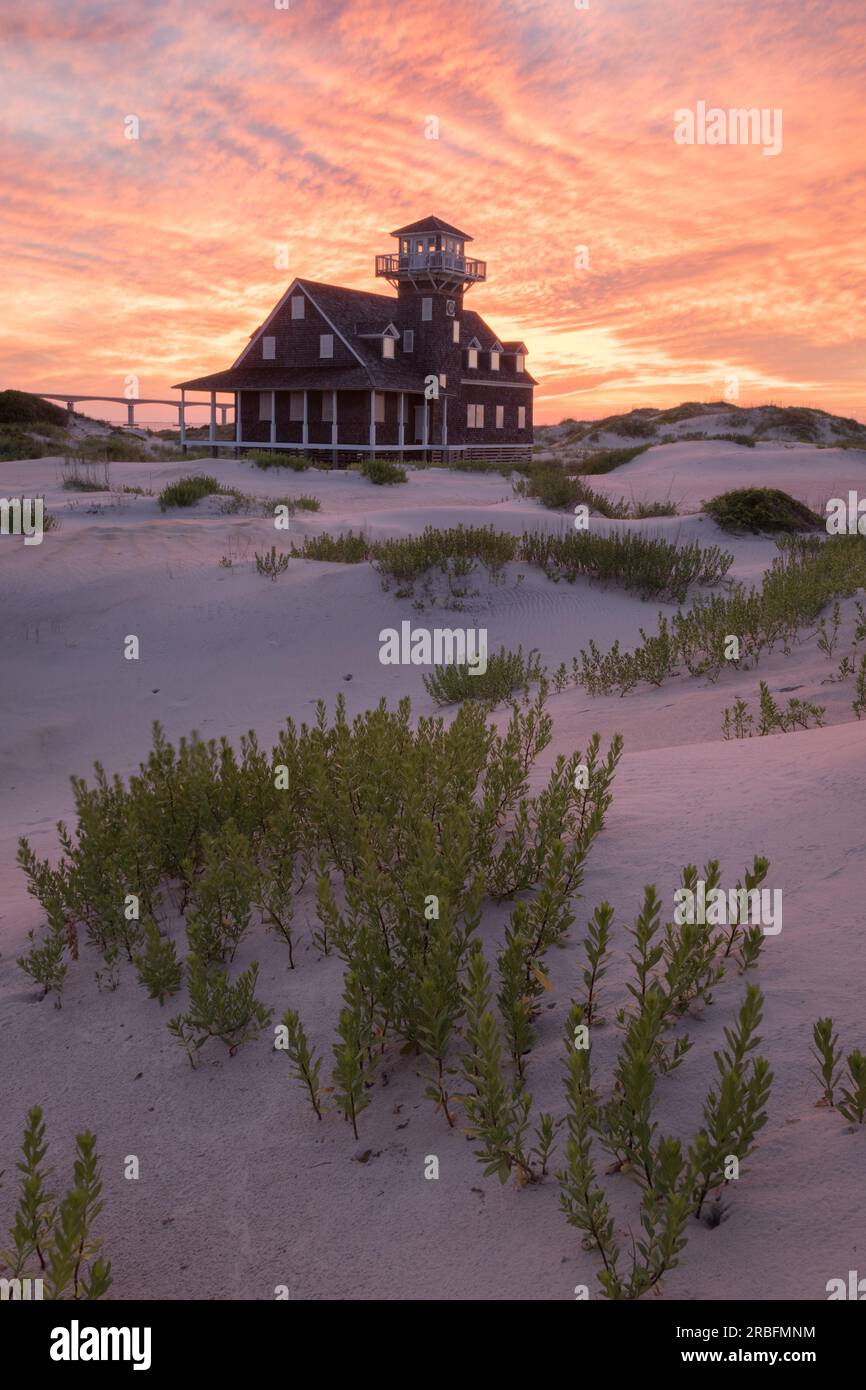 The historic Pea Island Life Saving Station with sand dunes under ...
