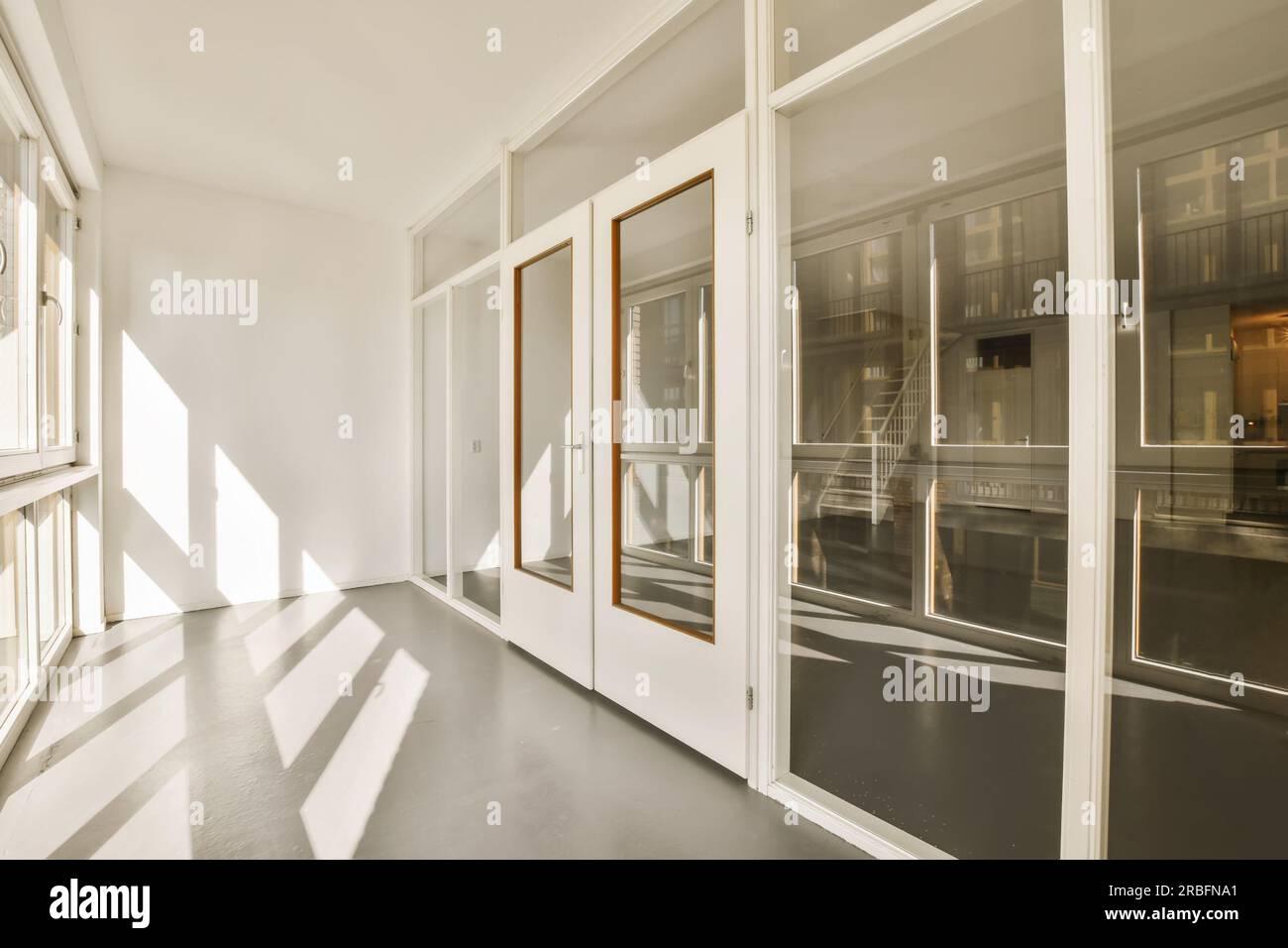 an empty room with large windows and sun shining through the window ...