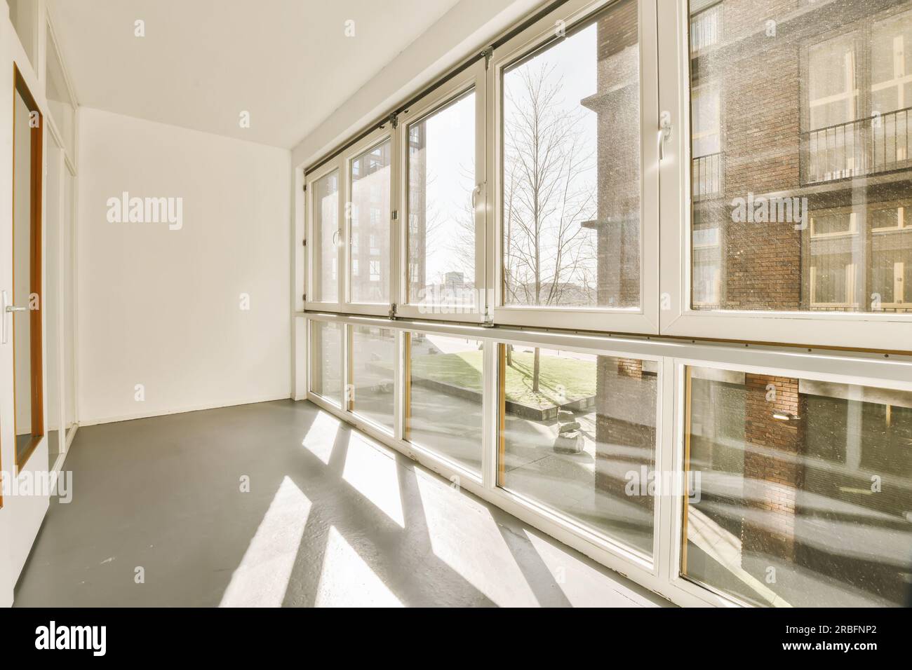 an empty room with large windows and no one person in the photo is ...