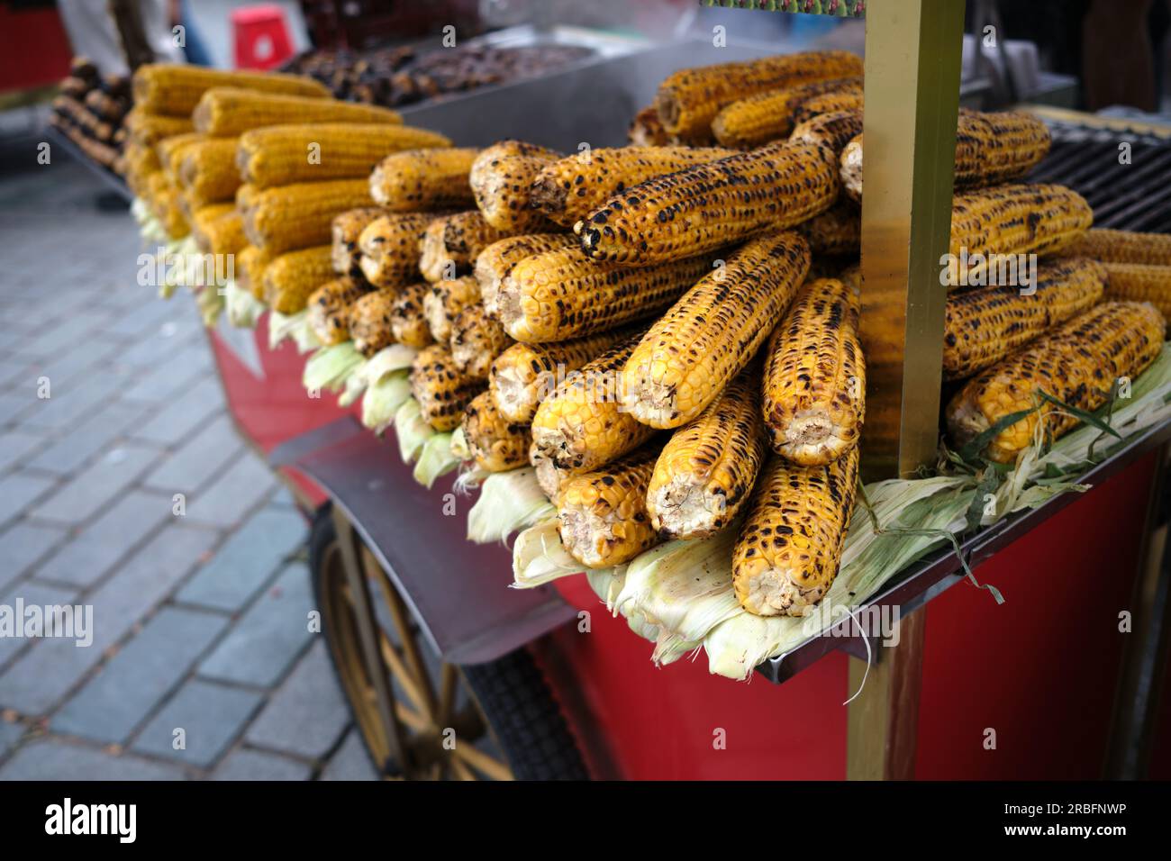 Grilled corn cobs lie on a street vendor's wheelbarrow Stock Photo - Alamy