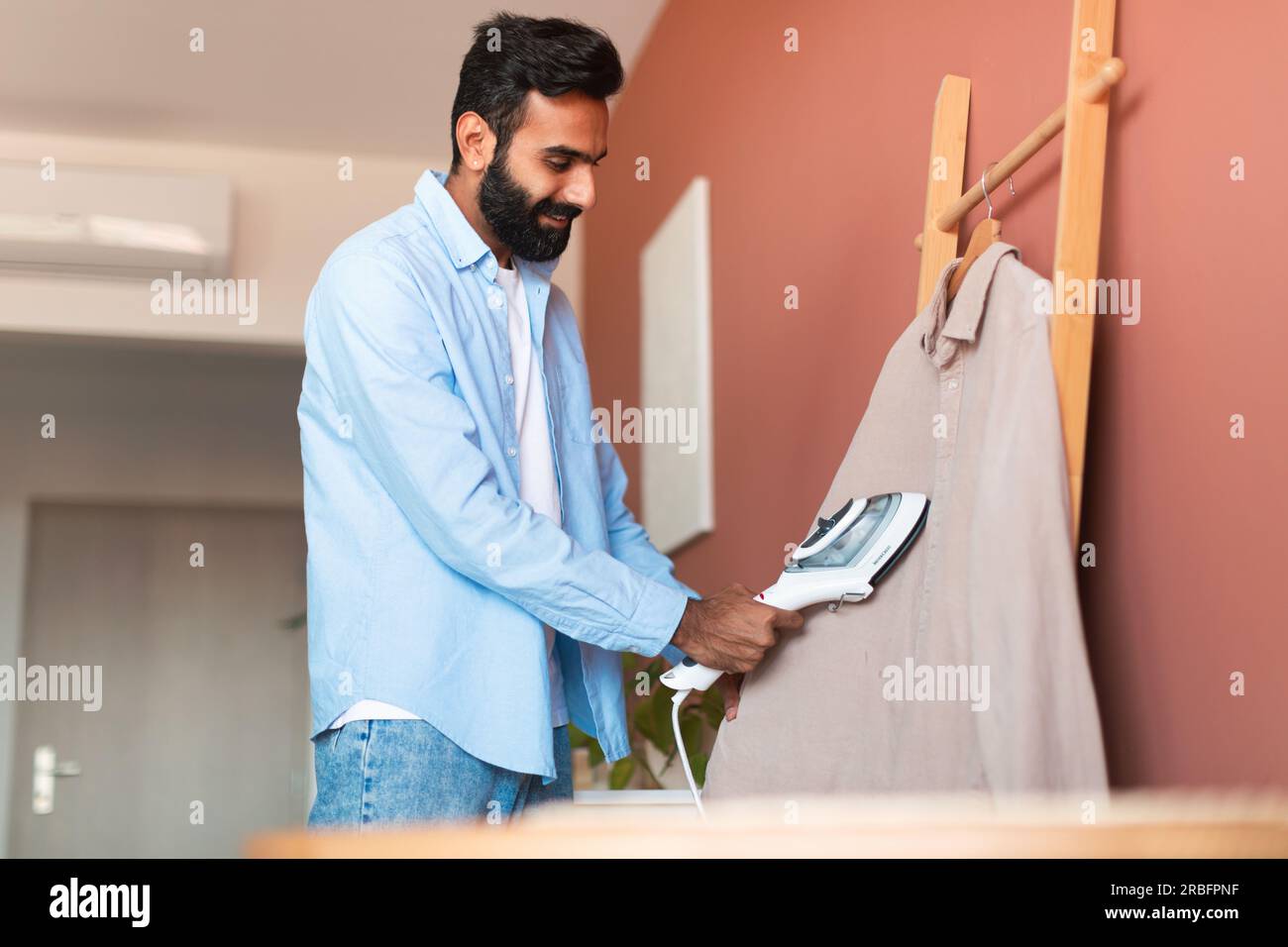 Happy Middle Eastern Young Man Using Clothes Steamer At Home Stock ...