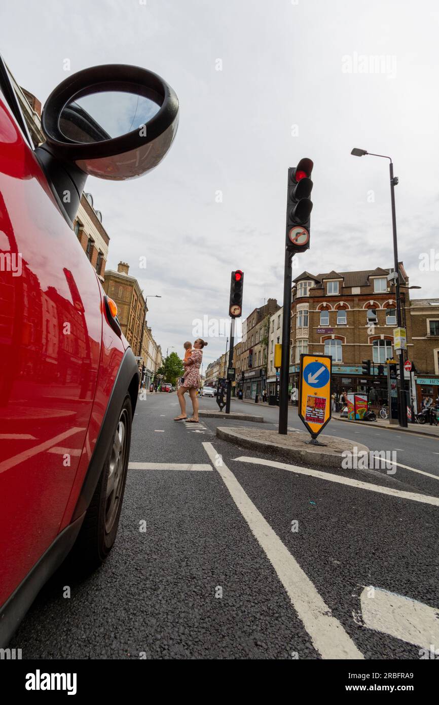 Red car Mini Cooper waiting by the traffic light. Stop at the red light ...