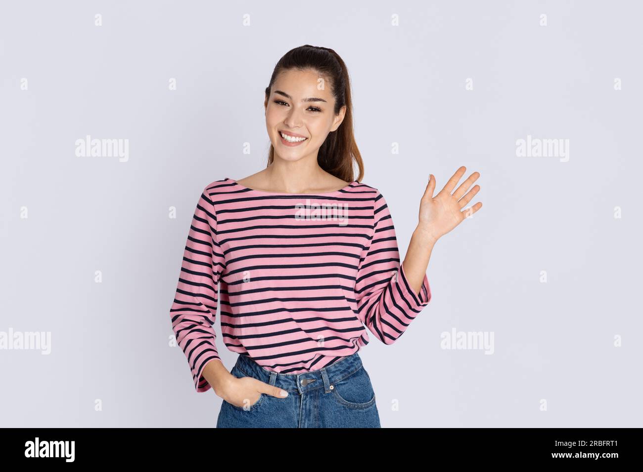 Positive cool young brunette woman waving at camera Stock Photo - Alamy