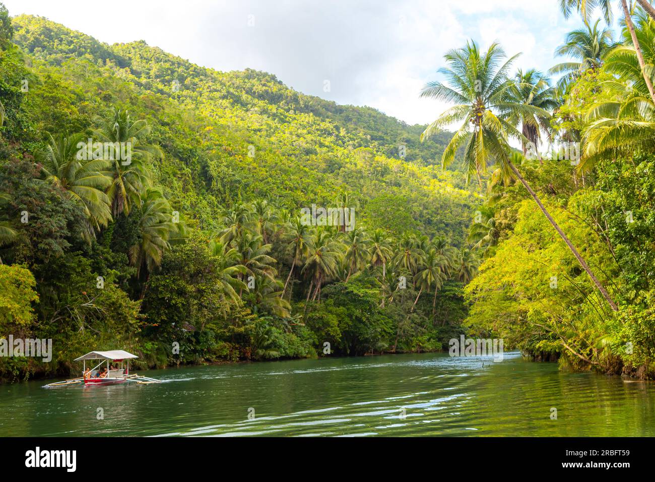 Exotic cruise boat with tourists on a jungle river Loboc, Bohol ...