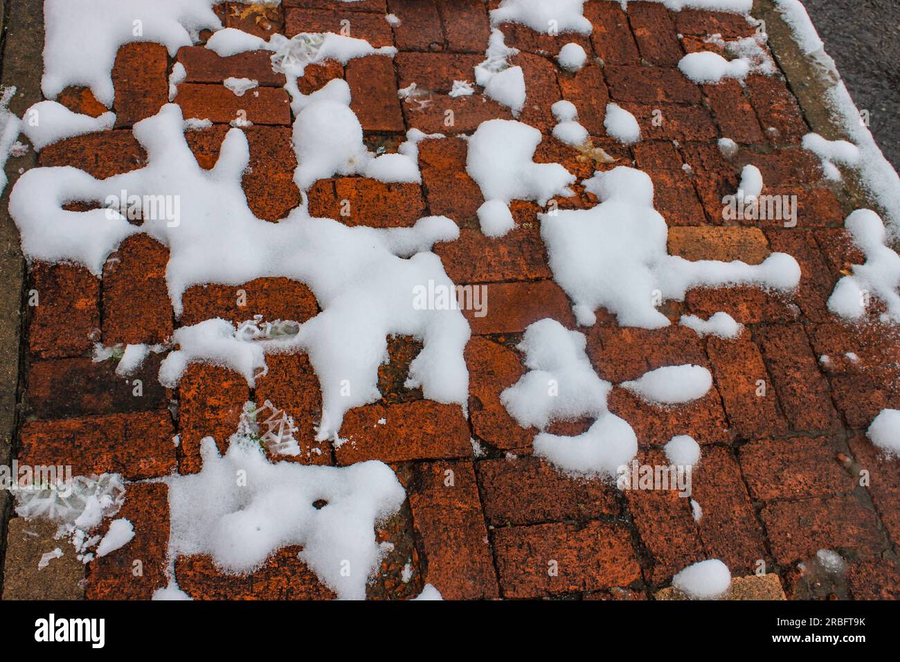 Snow melting but still visiable in blobs on orangish partly broken ...