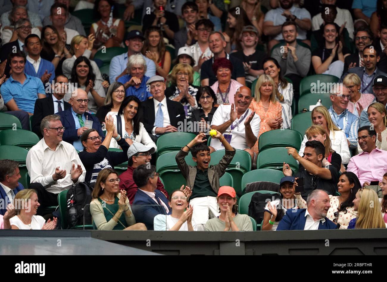 A young spectator catches a ball hit into the stands of centre court on ...