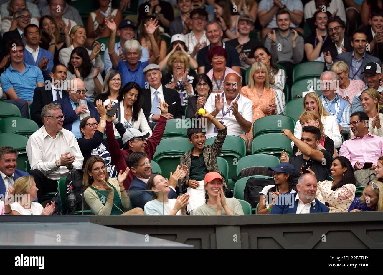 A young spectator catches a ball hit into the stands of centre court on ...