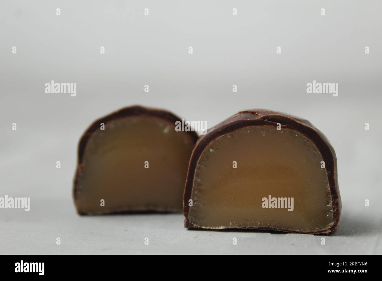 Chocolate body candy in a cut with a creamy praline filling on a white ...