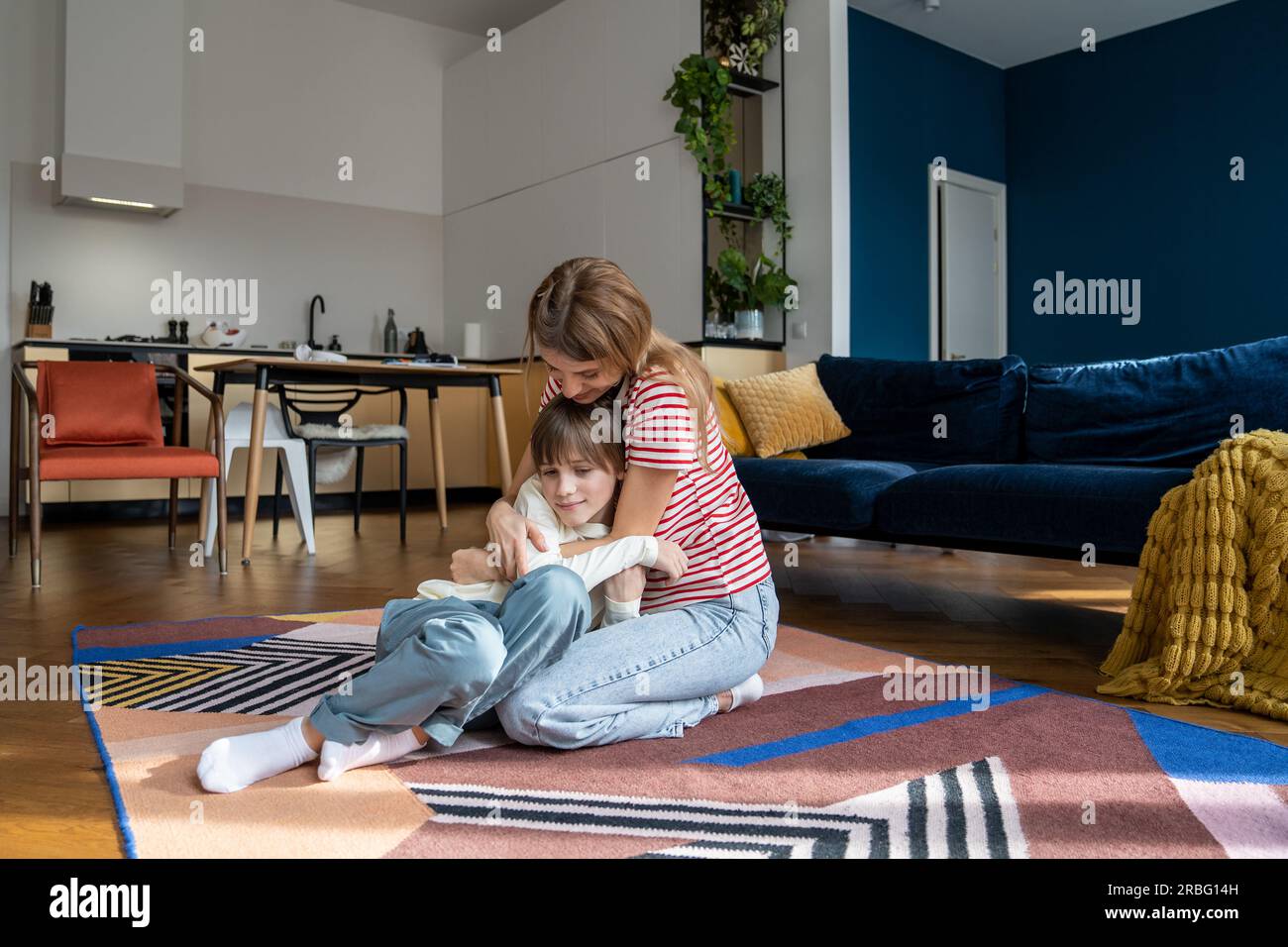 Caring mother sitting on floor hugging little boy son showing tender love trust support enjoy ...
