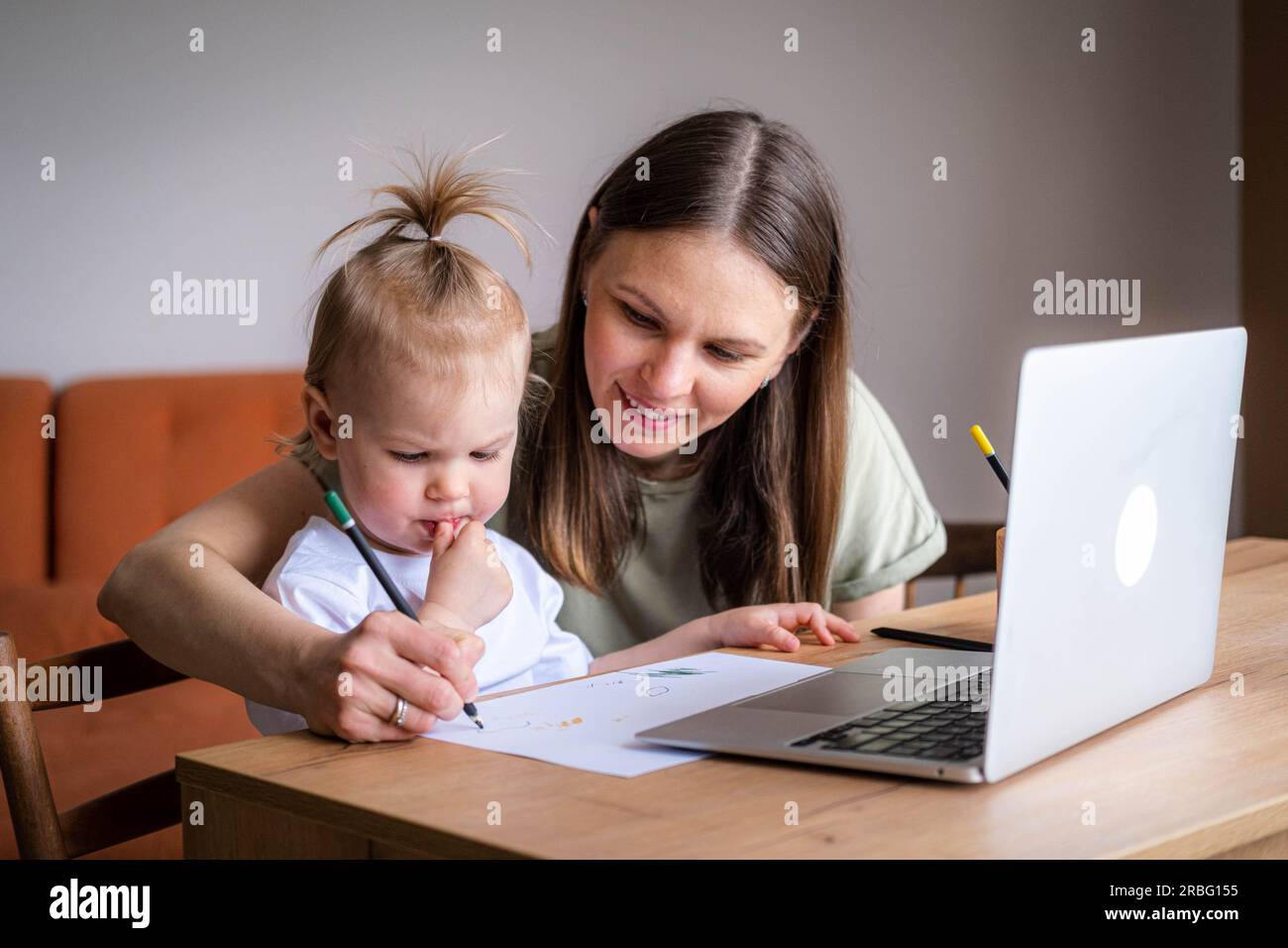 happy family mother and little baby daughter do homework using laptop ...