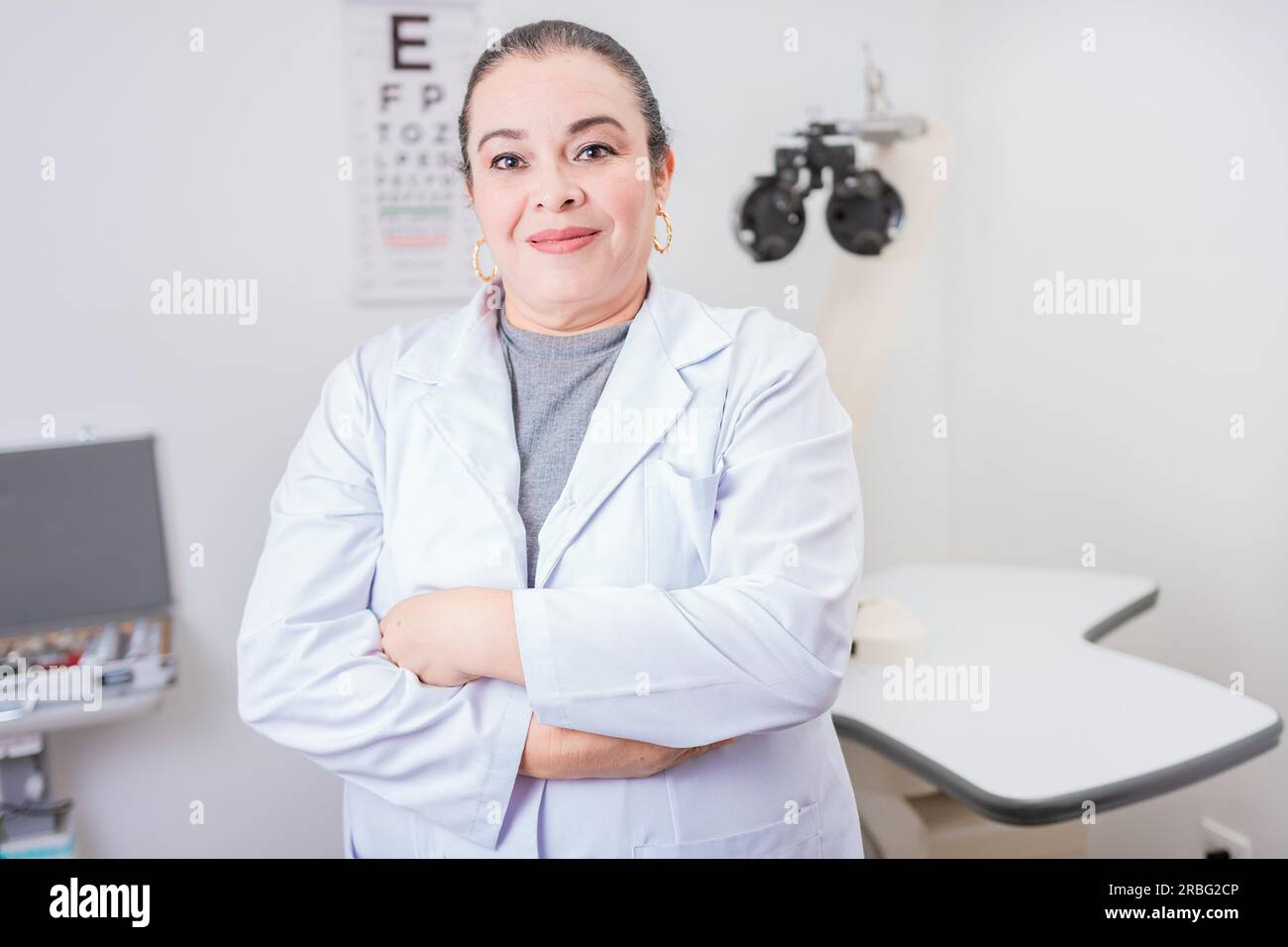Portrait of female optometrist with arms crossed in the laboratory ...