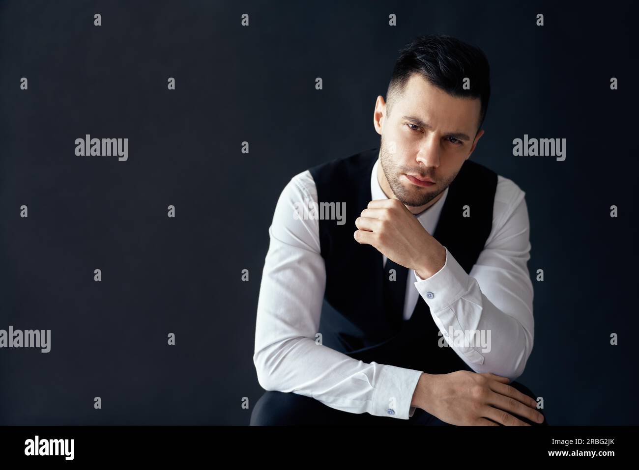 Handsome thoughtful man portrait in suit on dark background. Men beauty ...