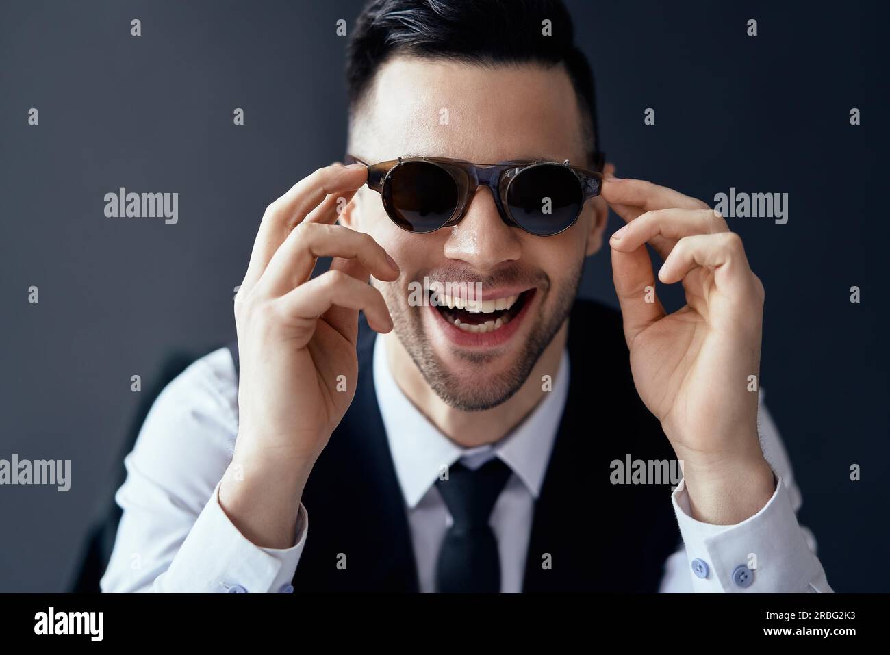 Happy laughing man in retro sunglasses on black background. Fun concept ...