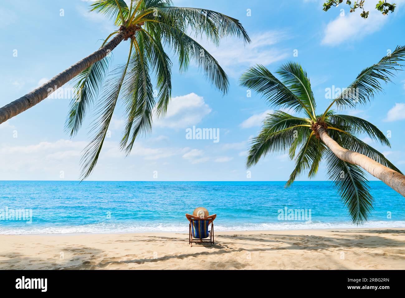 Back view of young beautiful woman sunbathe and relax on tropical beach ...