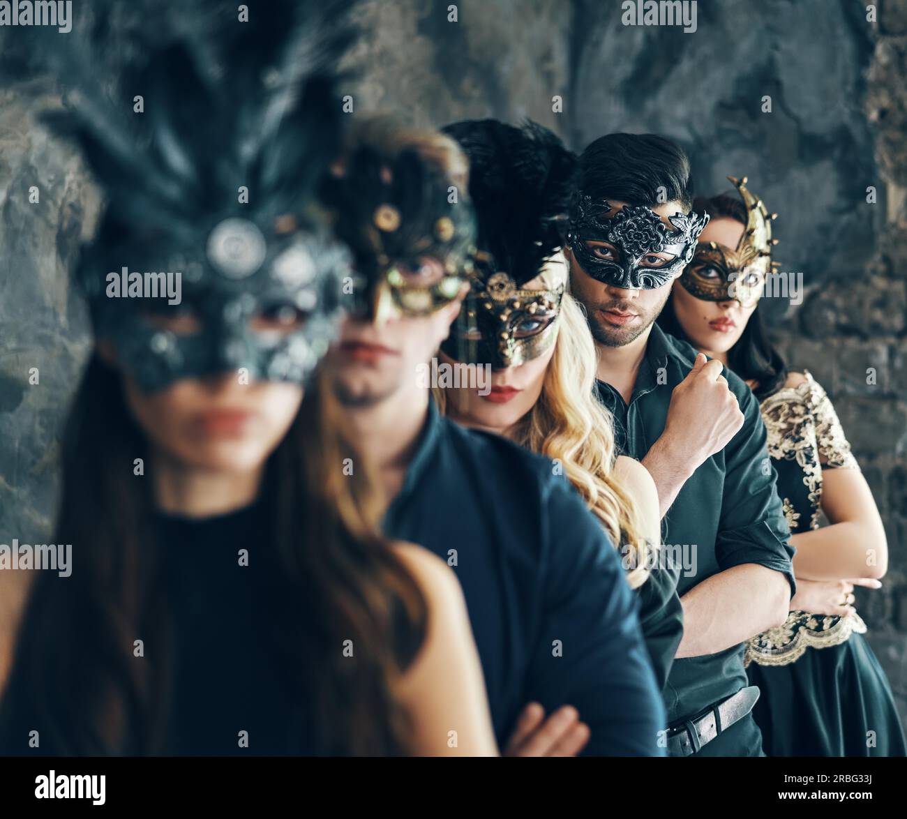 Group of people in masquerade carnival mask posing in studio. Beautiful ...