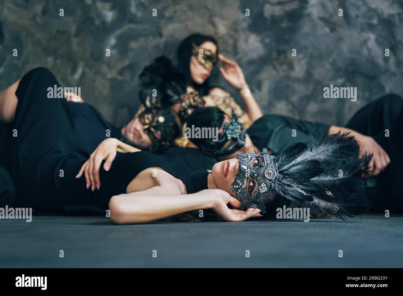 Group of friends in masquerade carnival mask sitting on floor relax ...