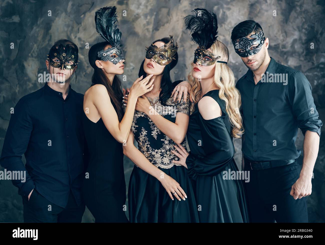 Group of people in masquerade carnival mask posing in studio. Beautiful ...