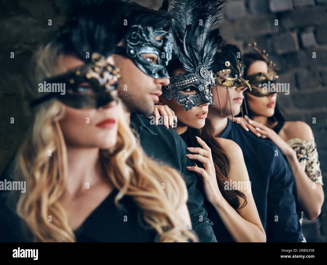 Group of people in masquerade carnival mask posing in studio. Beautiful ...