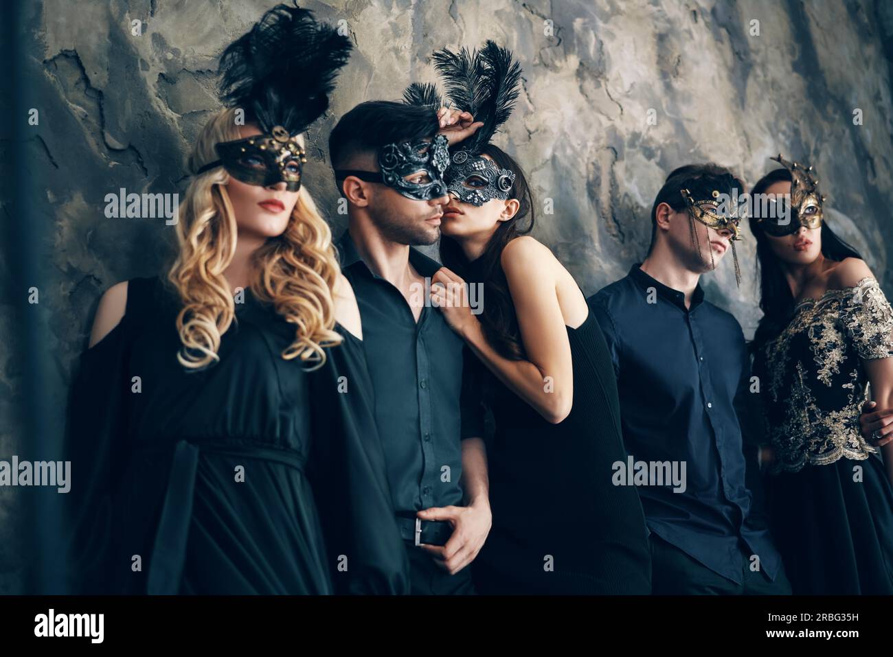 Group of people in masquerade carnival mask posing in studio. Beautiful ...