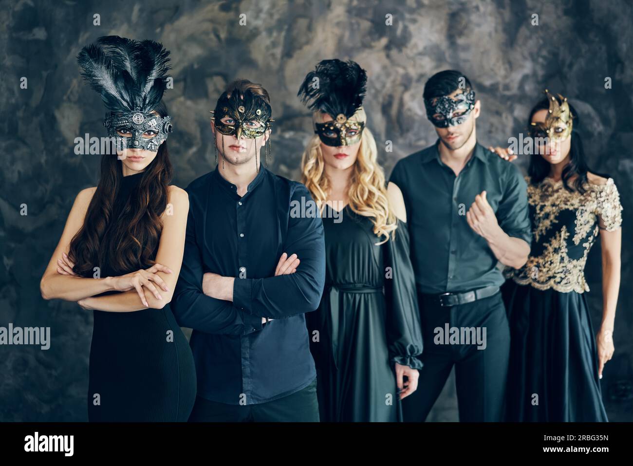 Group of people in masquerade carnival mask posing in studio. Beautiful ...