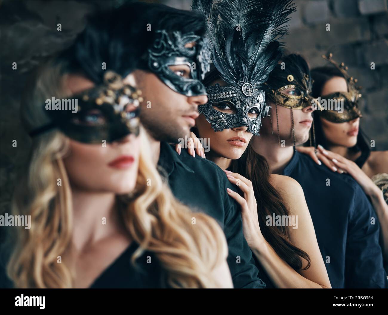 Group of people in masquerade carnival mask posing in studio. Beautiful ...