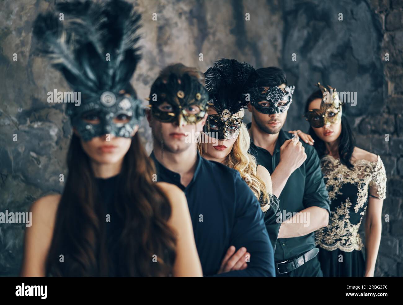 Group of people in masquerade carnival mask posing in studio. Beautiful ...