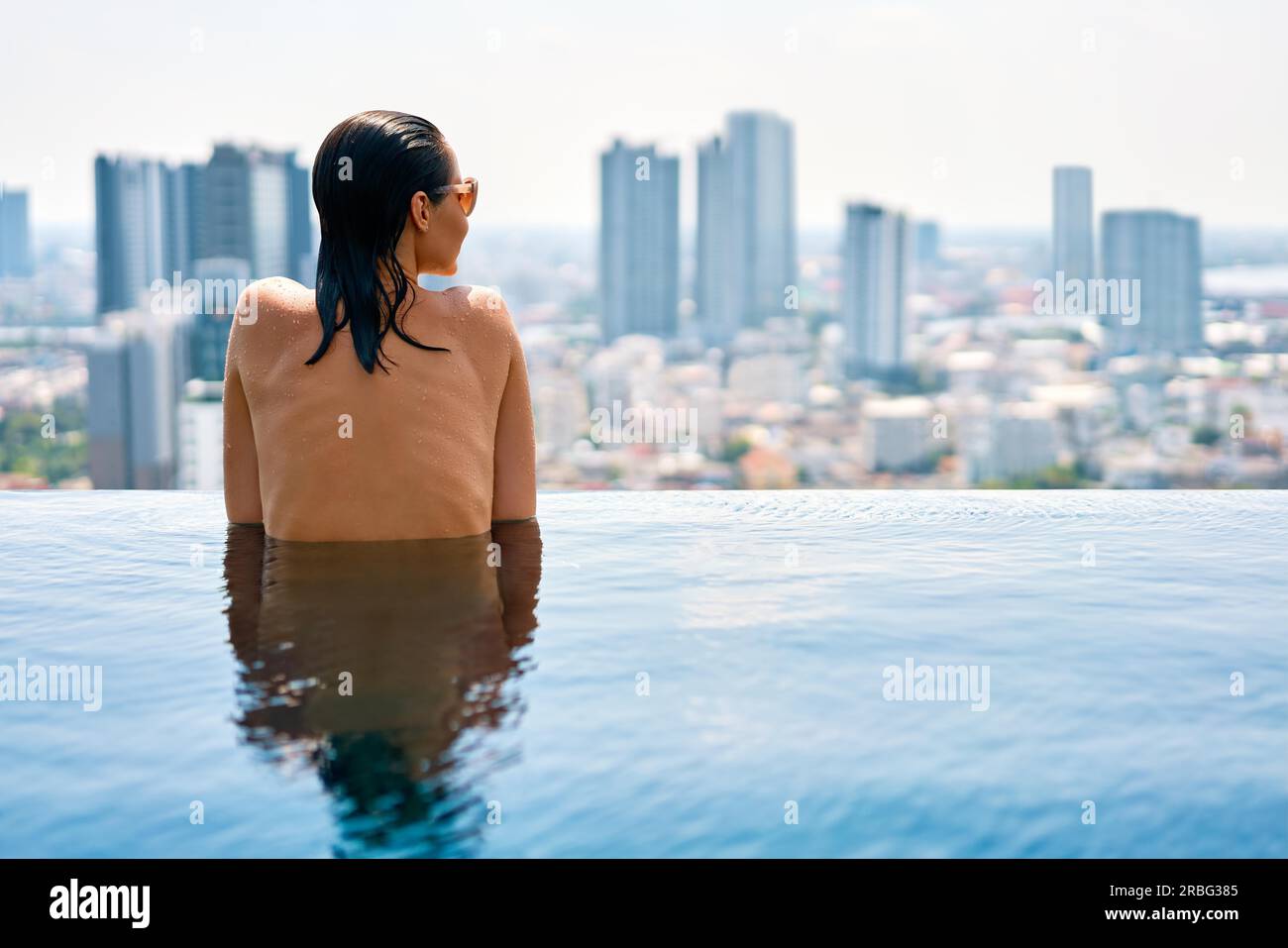 Back view of slim beautiful woman relax in swimming pool. Summer ...