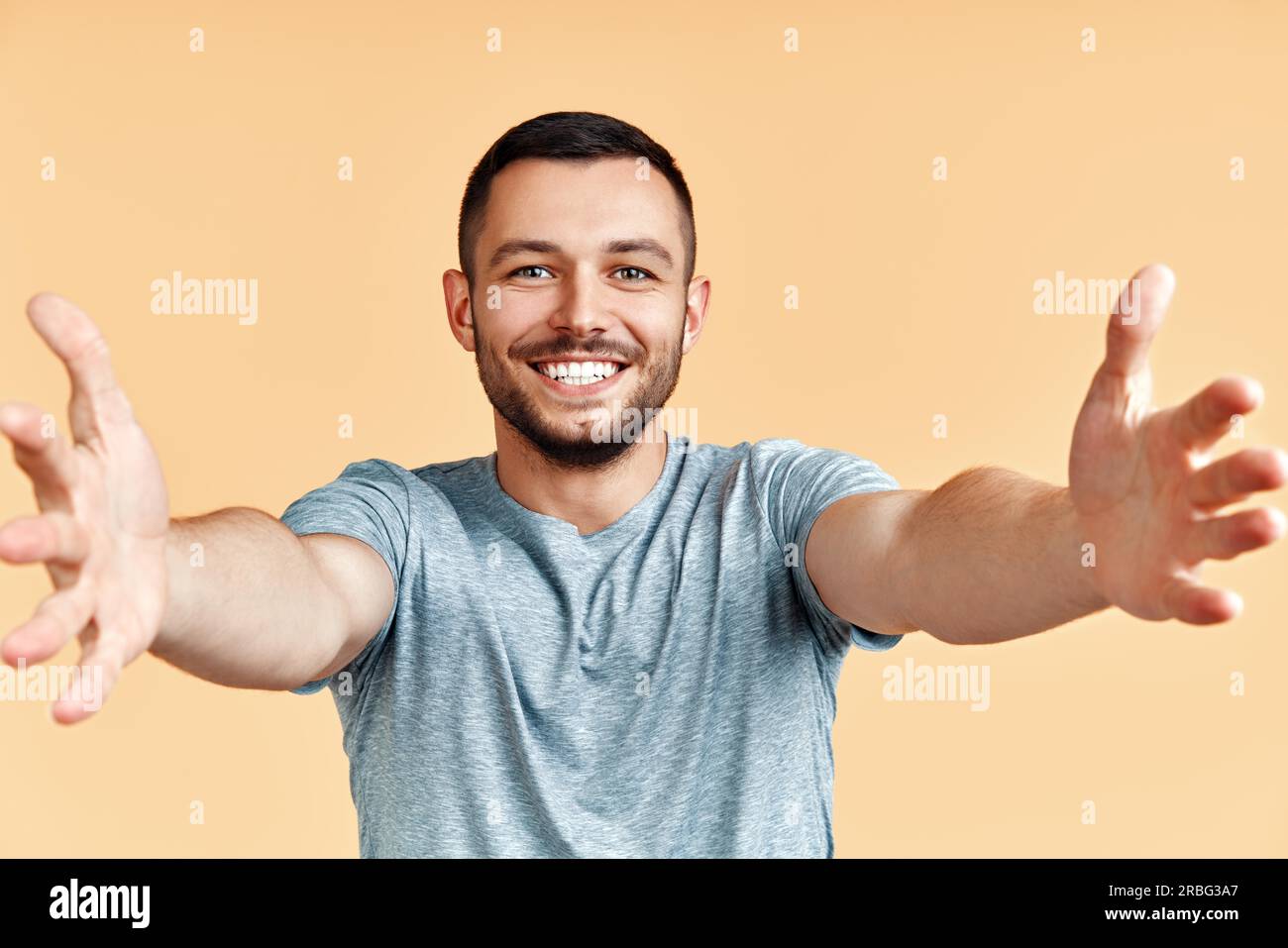 Handsome Happy Man With Open Hand Ready For Hugs On Yellow Background