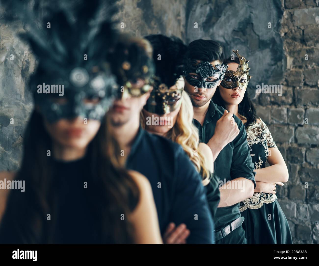Group of people in masquerade carnival mask posing in studio. Beautiful ...