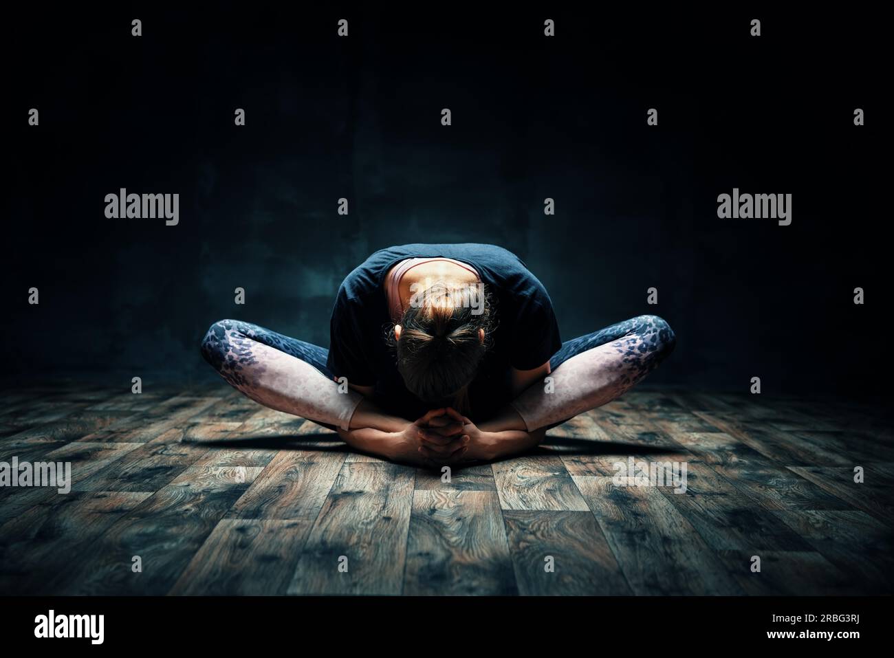Young woman practicing yoga doing reclined goddess pose asana in dark ...
