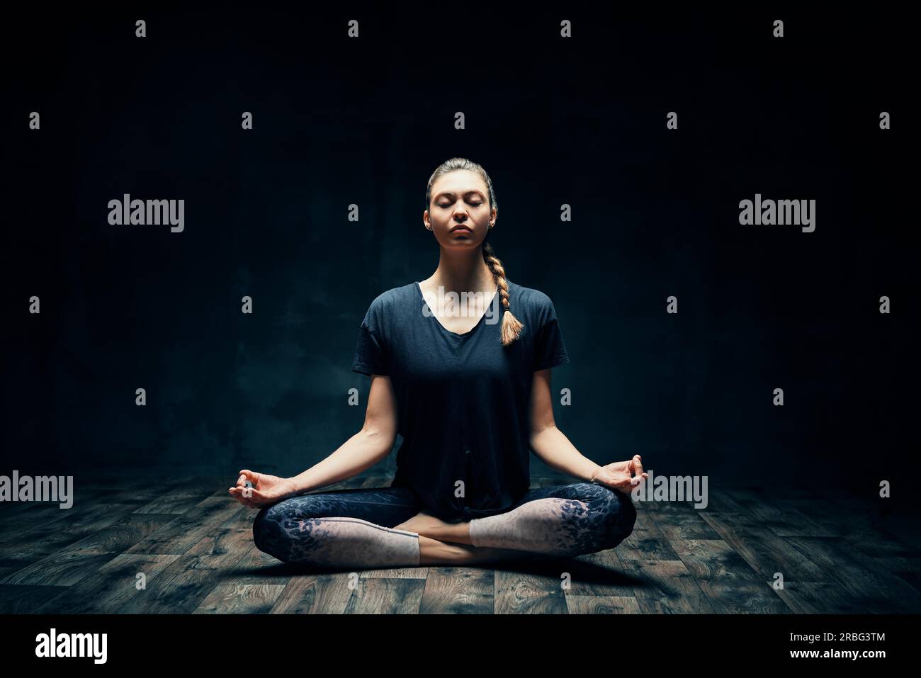 Young attractive woman practicing yoga sitting in lotus pose and ...