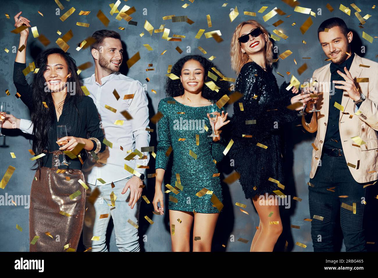 Happy young people dancing and having fun with confetti flying ...