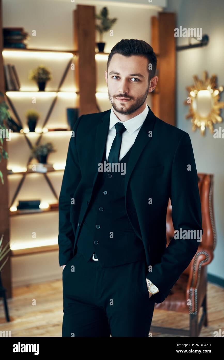Portrait of handsome elegant man in suit in modern luxury interior ...