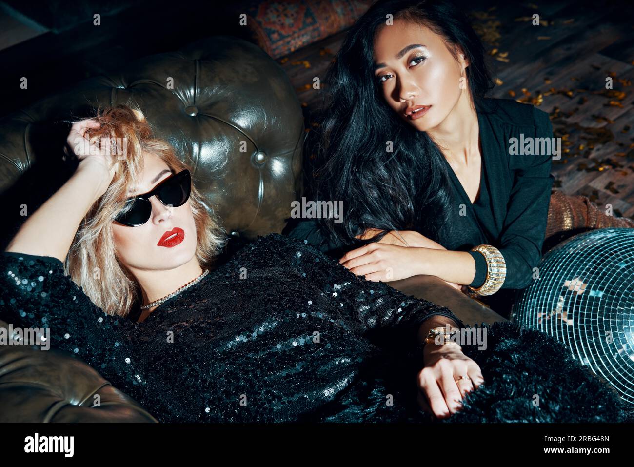 Two pretty multiethnic young women relaxed after party. Celebration and ...