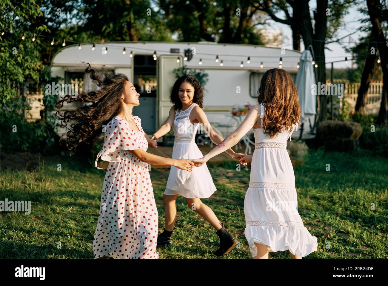 Happy beautiful women dancing outdoors on picnic. Multi ethnic girls ...