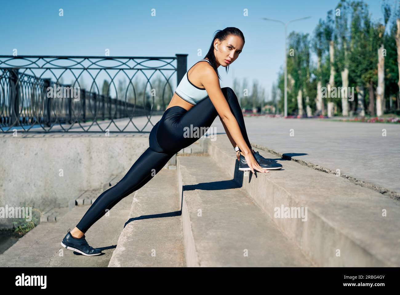 Sporty woman runner stretching legs for warming up before exercising ...