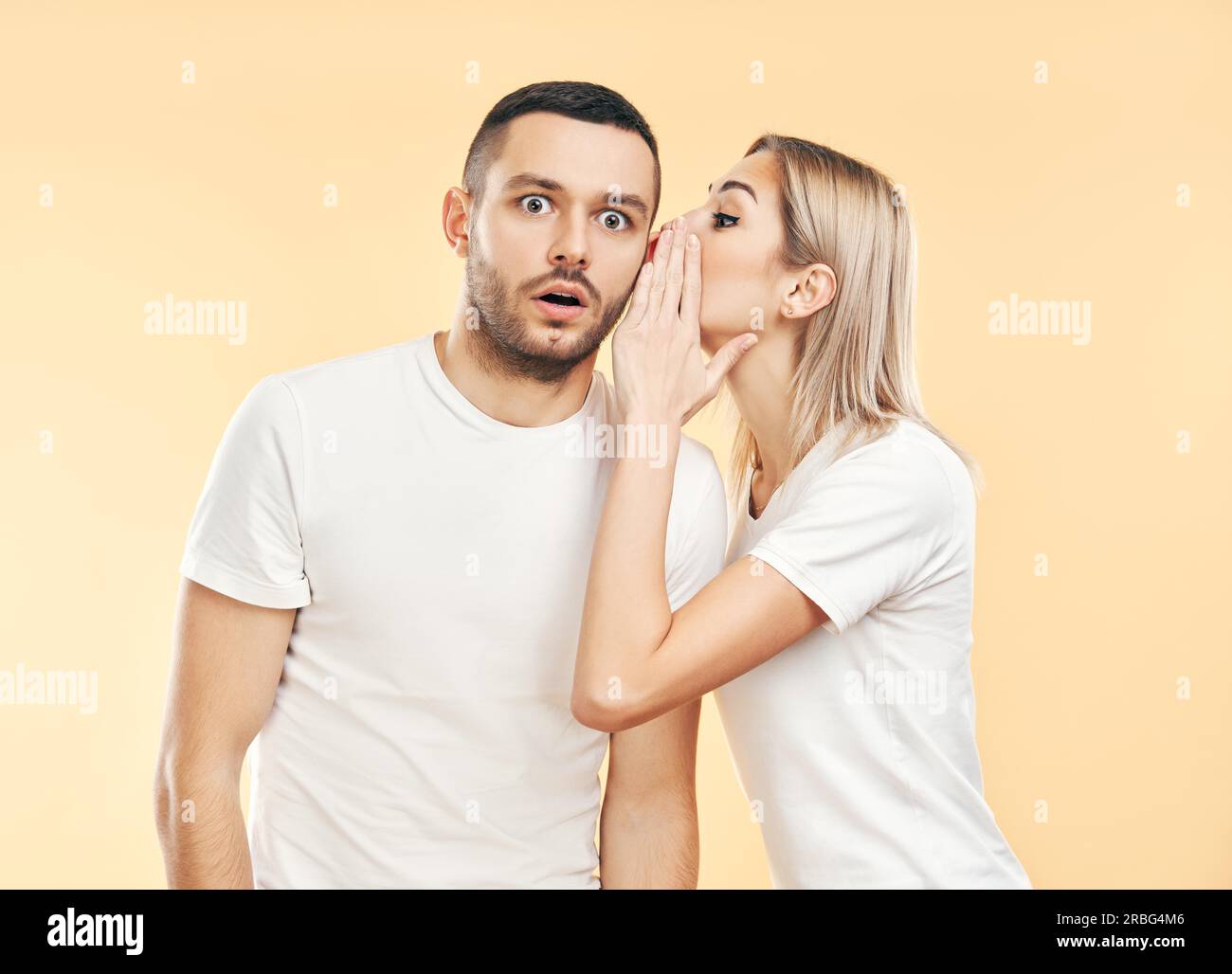 Young woman whispering secrets to man over beige background. Gossiping ...