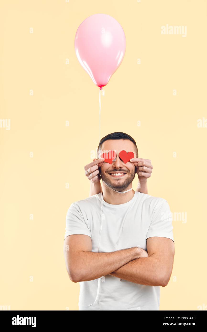 Weird funny man with small paper hearts by their eyes and pink air ...