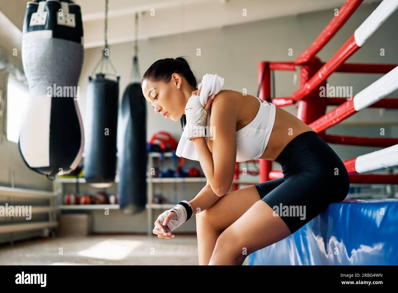 Young beautiful woman relax after fight or workout exercising in boxing ...