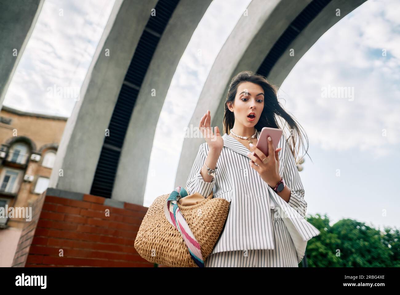 Shocked amazing woman woman looking on mobile phone in summer city ...