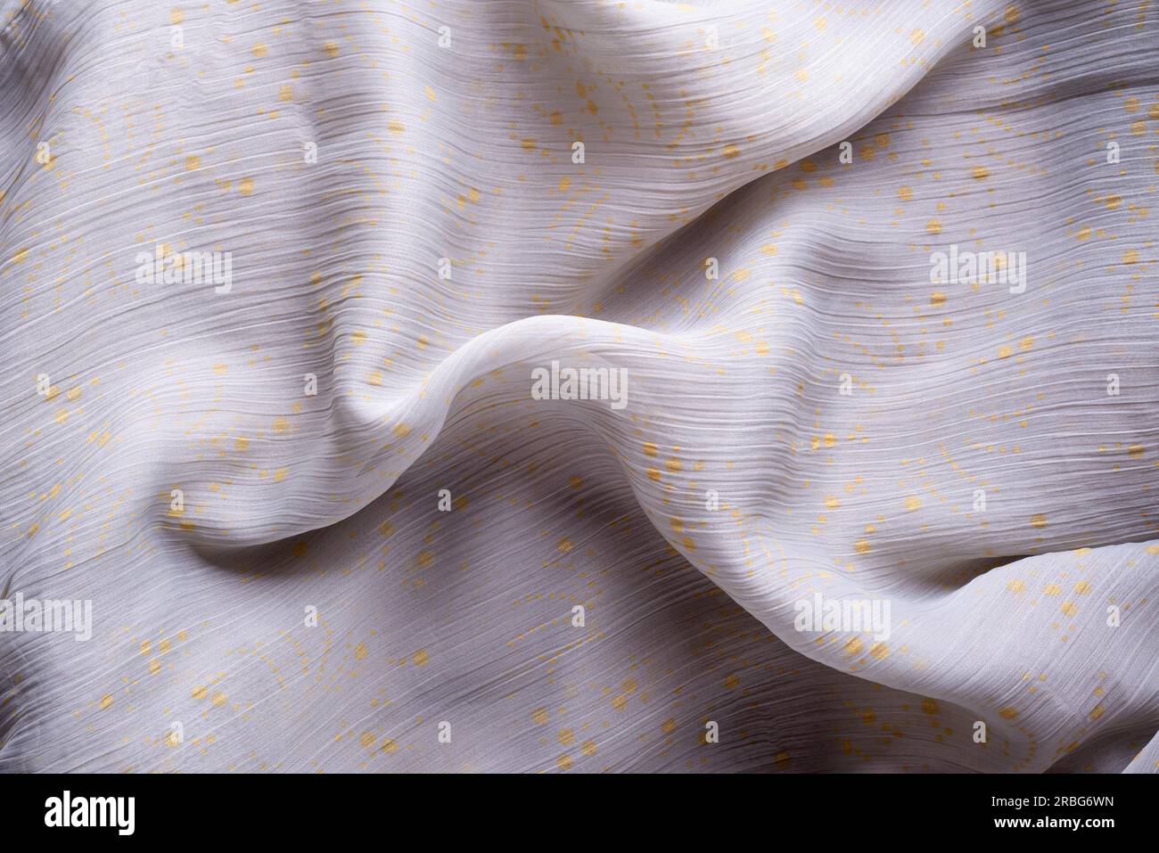 Soft folds of a light pink synthetic fabric texture with yellow gold ...