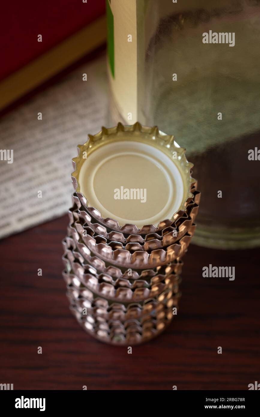 Beer or other soda and soft drinks caps, on a dark wood table in a bar ...