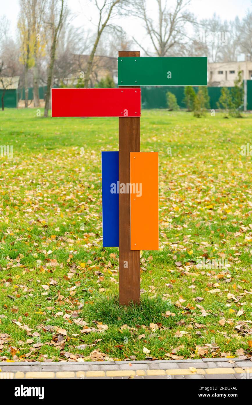 Blank directional arrow signs in the park, with a green grass ...