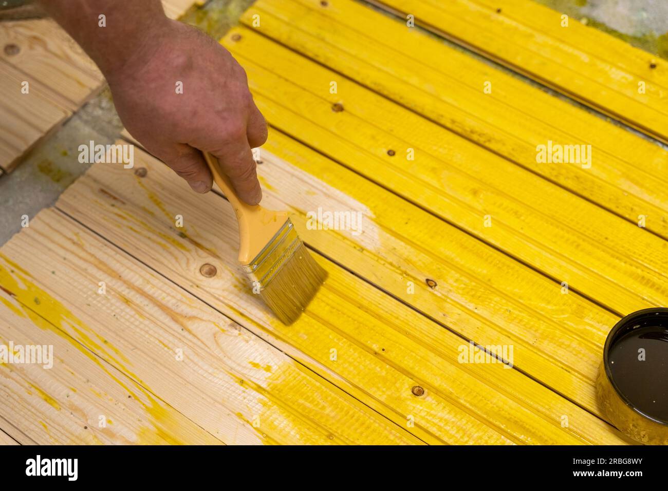 applying the protective composition on the board with a brush ...