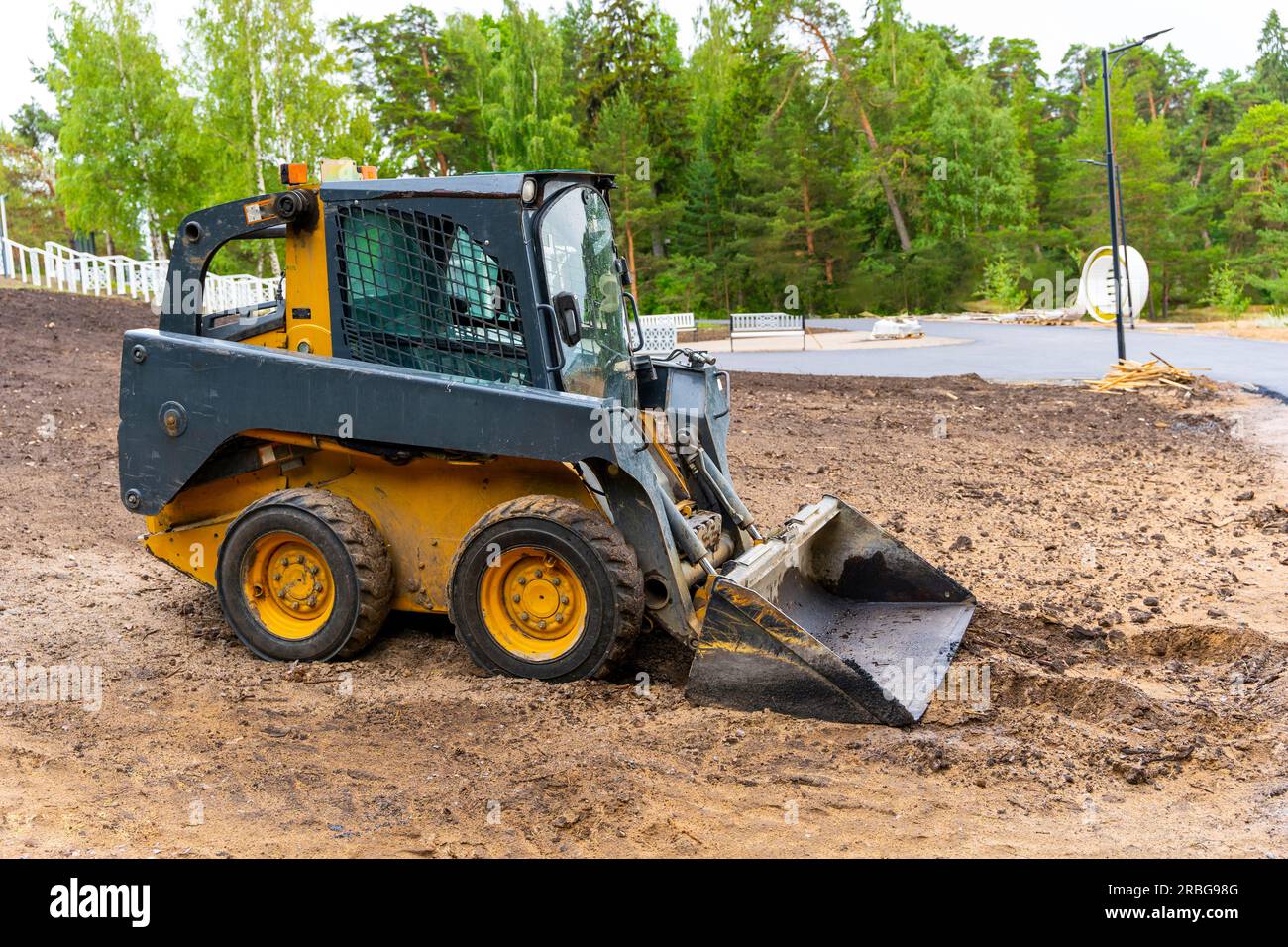 mini loader with bucket. A loader with a bucket clears the site for ...