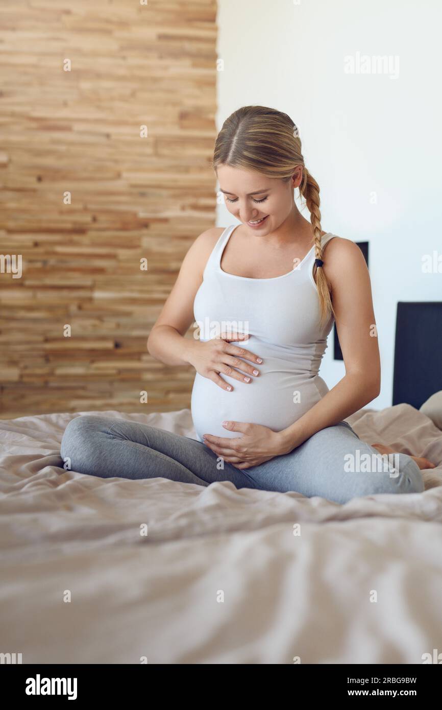 Happy young pregnant woman bonding with her unborn child sitting on a ...