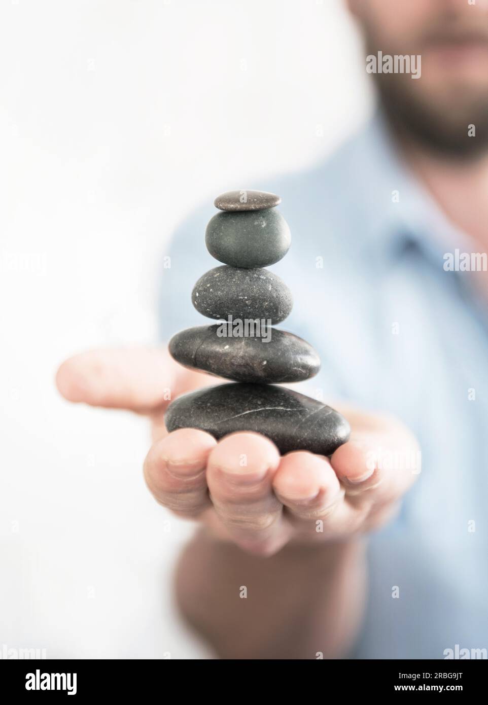 Man balancing stones Stock Photo - Alamy
